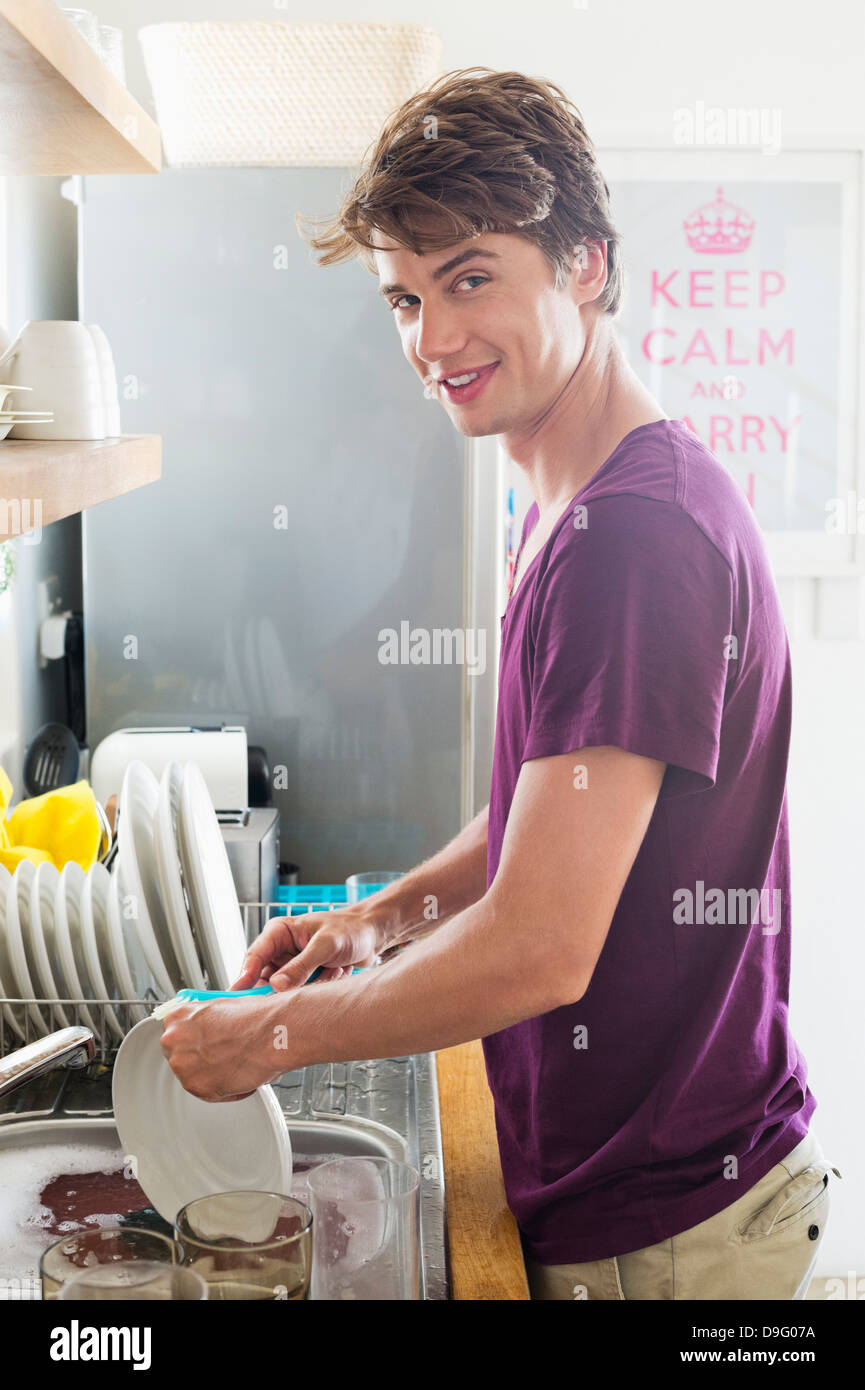 Man washing dishes in his kitchen Stock Photo - Alamy