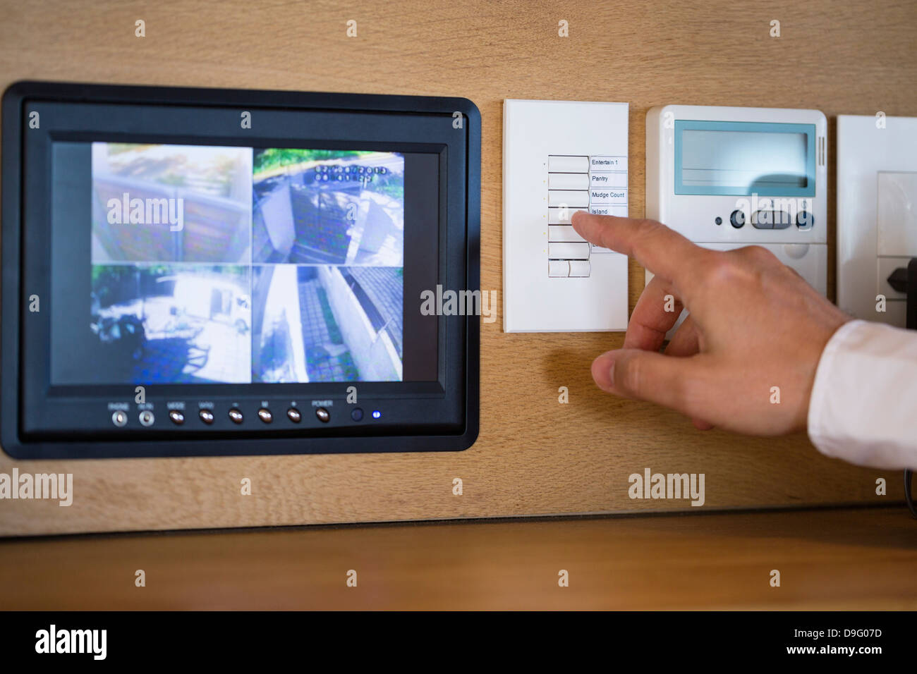 Person's hand pushing buttons for a security surveillance system at ...