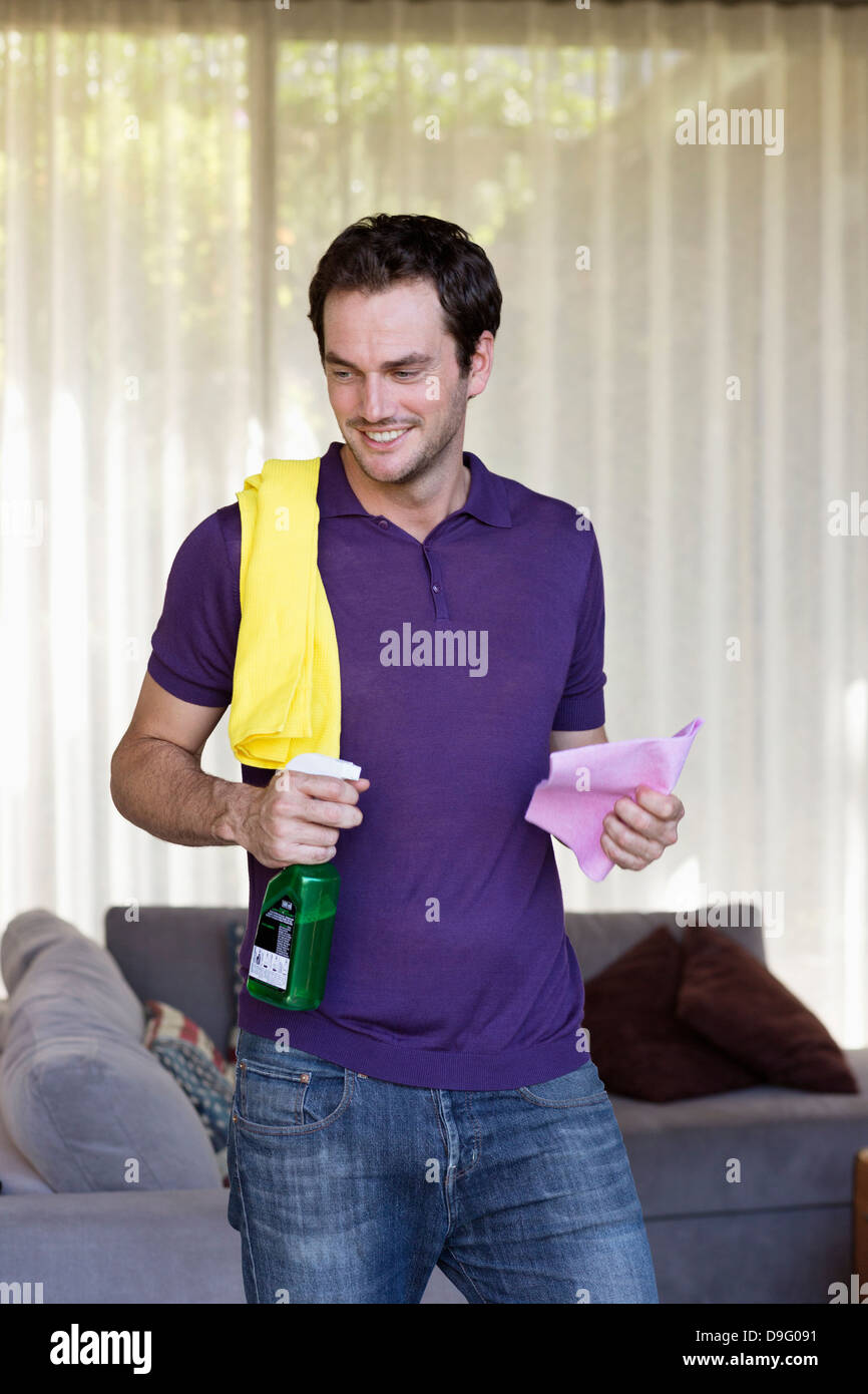 Smiling man holding cleaning equipment Stock Photo - Alamy