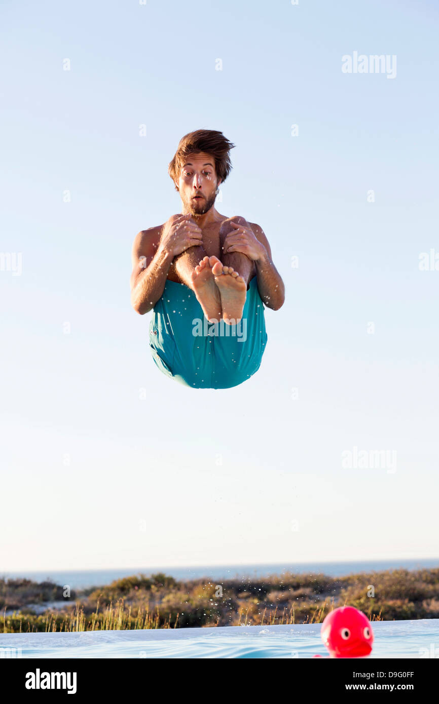 Man jumping into a swimming pool Stock Photo - Alamy
