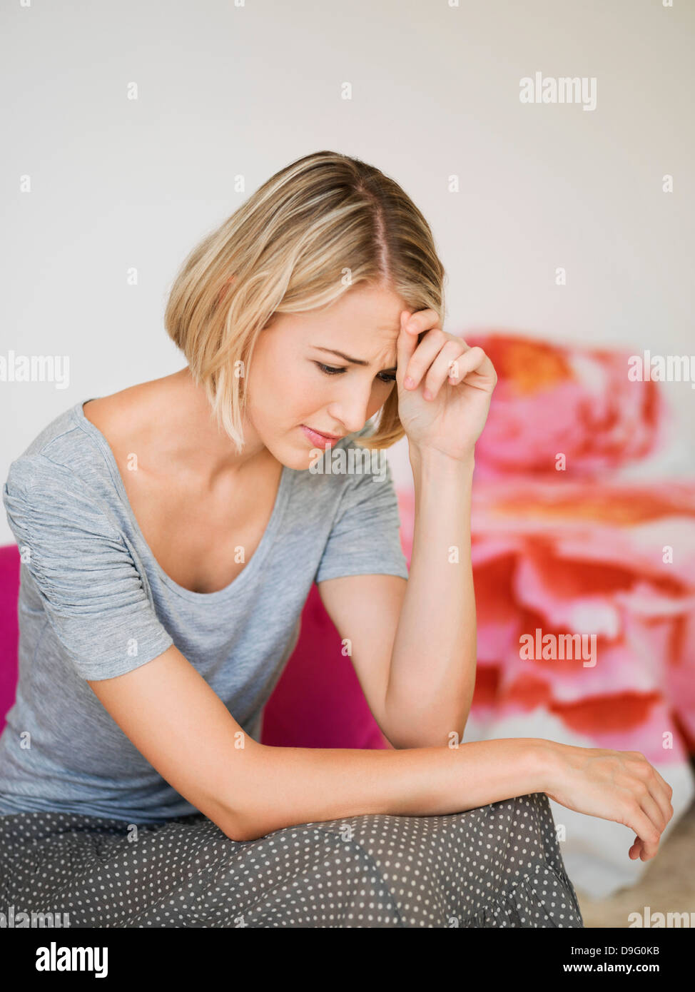 Woman sitting on an armchair and thinking Stock Photo - Alamy