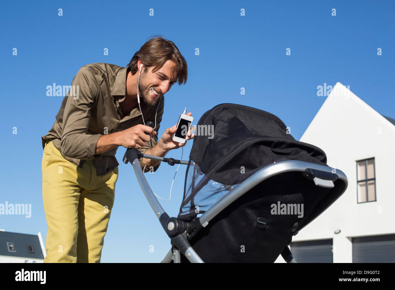 Man showing mobile phone to a baby in stroller Stock Photo - Alamy