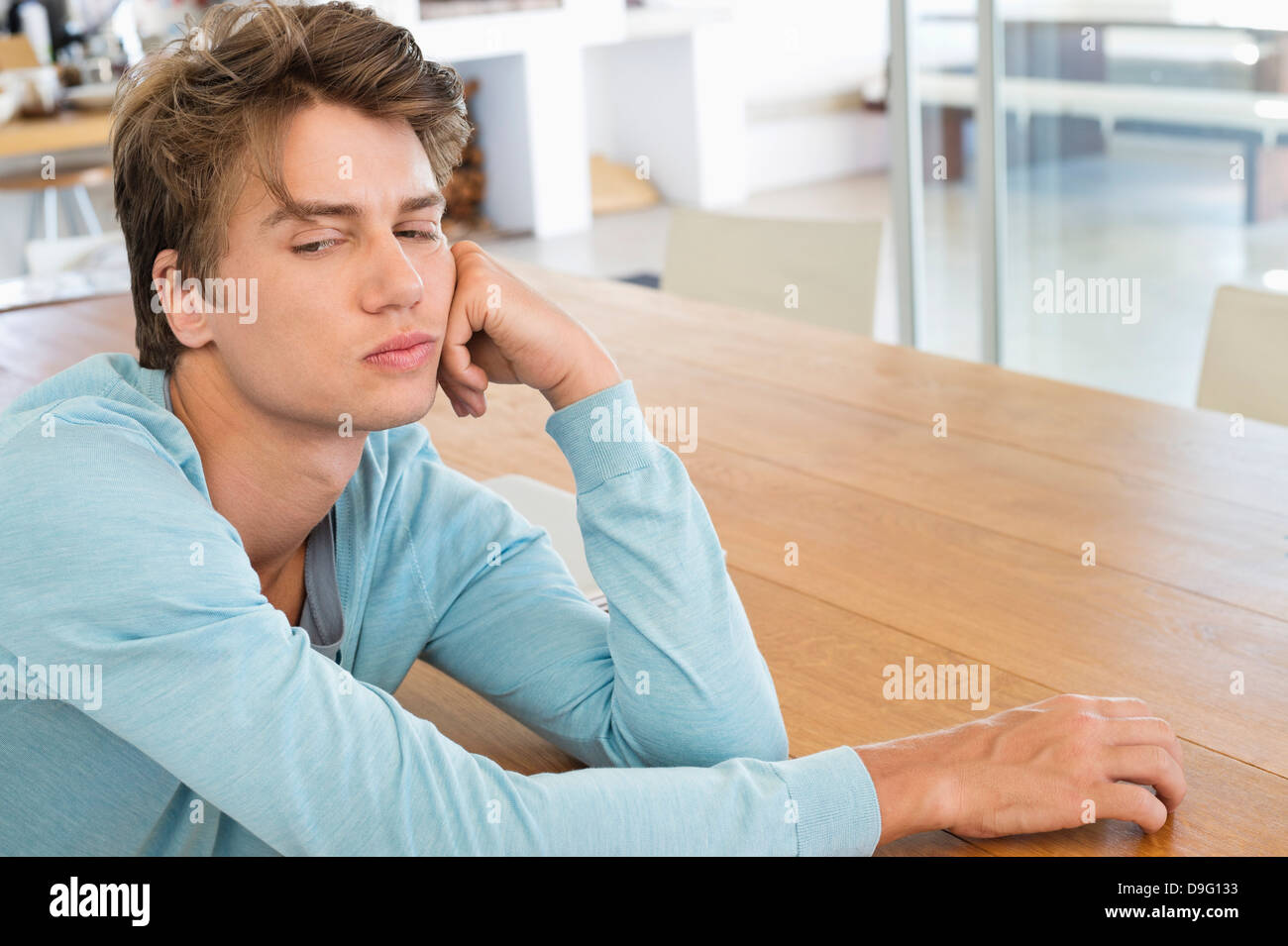 Man leaning on a table and thinking Stock Photo - Alamy