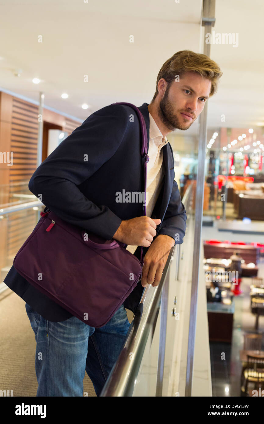 Man leaning against a railing looking away Stock Photo - Alamy