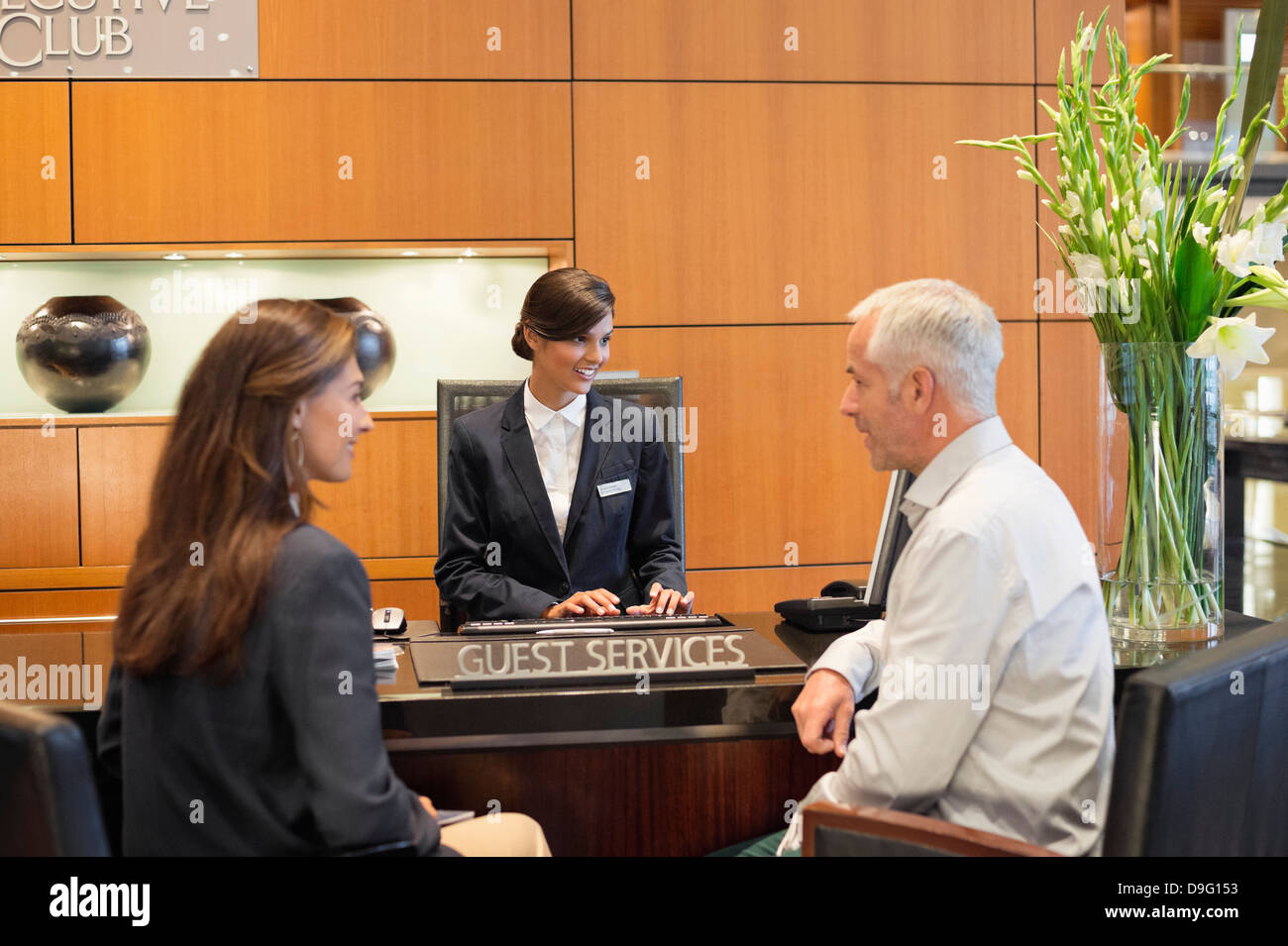 Business couple talking at a hotel reception counter Stock Photo - Alamy