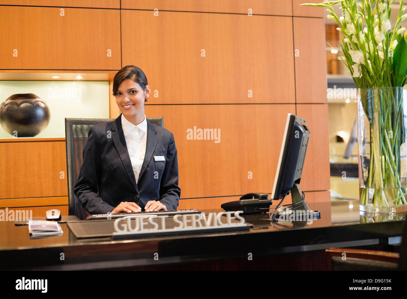 Portrait of a receptionist smiling at the hotel reception counter Stock ...
