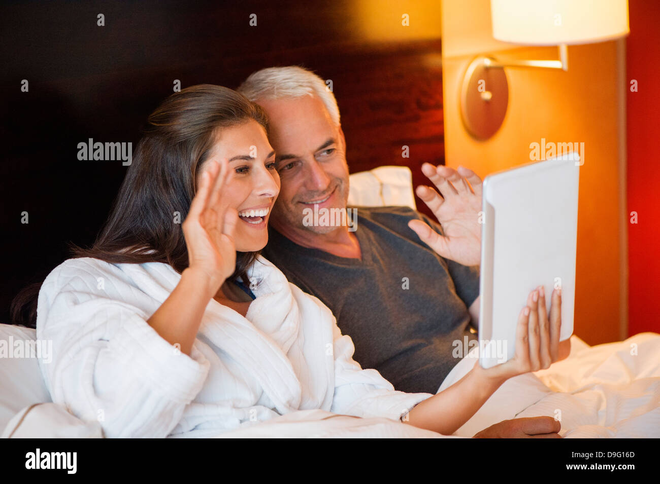 Couple video calling on a digital tablet in a hotel room Stock Photo ...
