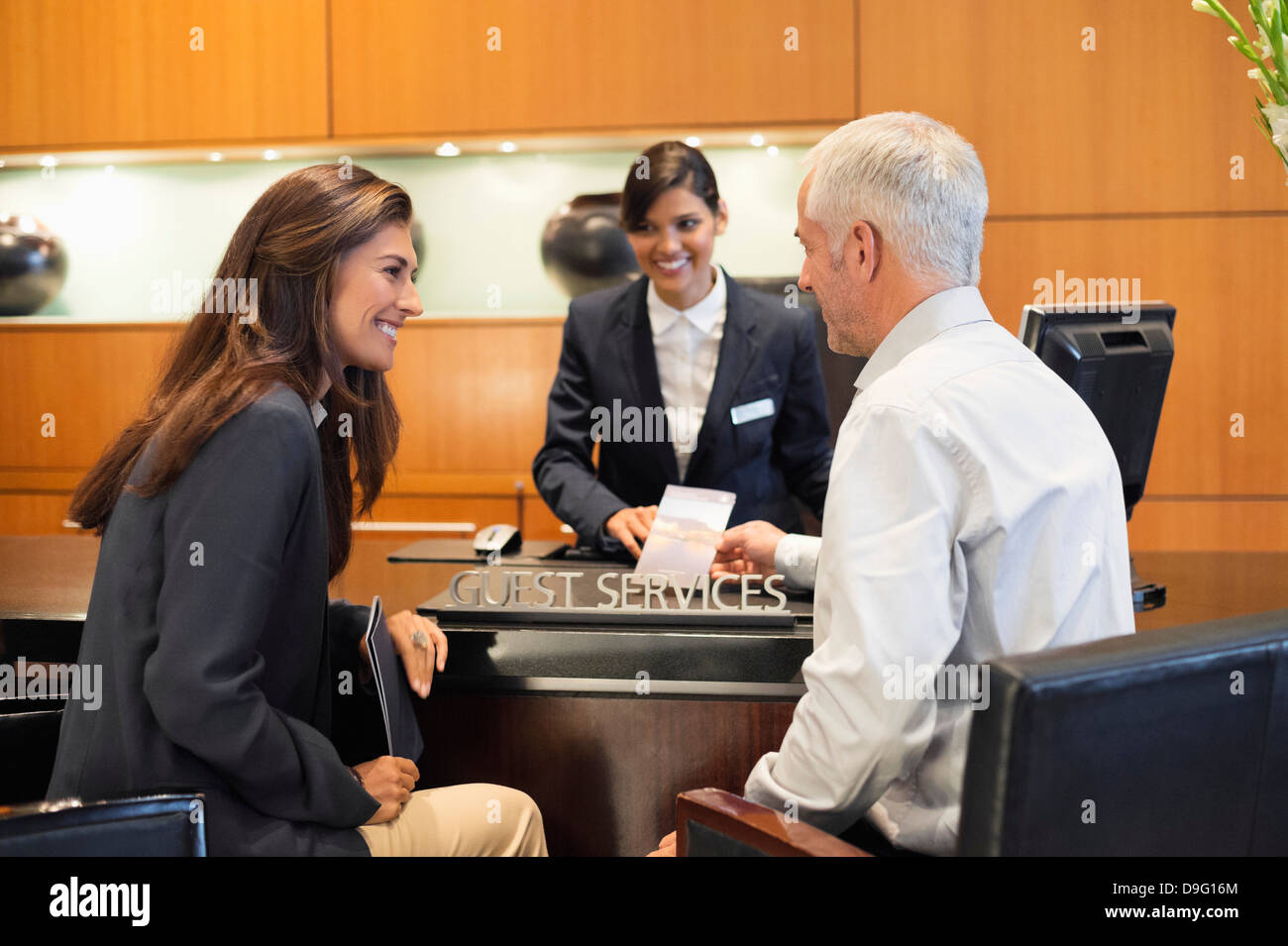 Business couple talking at a hotel reception counter Stock Photo - Alamy