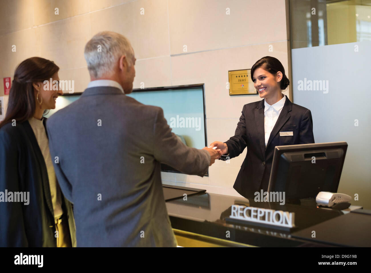 Business couple getting key card at the hotel reception counter Stock ...