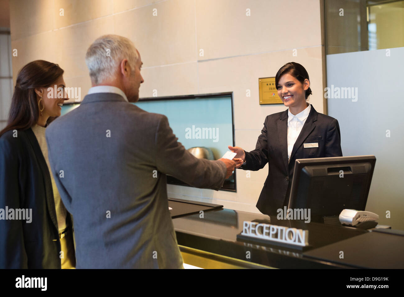 Business couple getting key card at the hotel reception counter Stock ...
