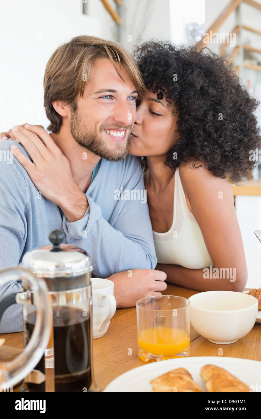 Woman kissing her husband at a dining table Stock Photo - Alamy