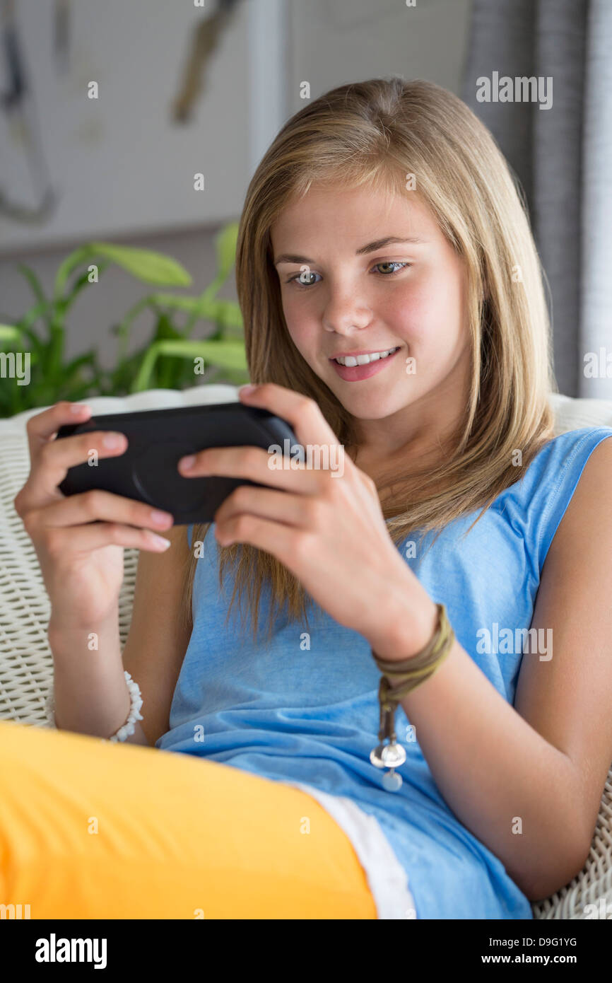 Girl playing a video game and smiling Stock Photo - Alamy