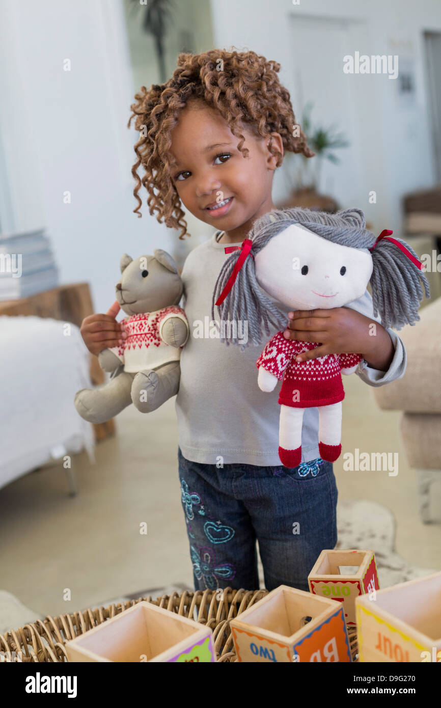 Portrait of a girl standing with dolls Stock Photo - Alamy