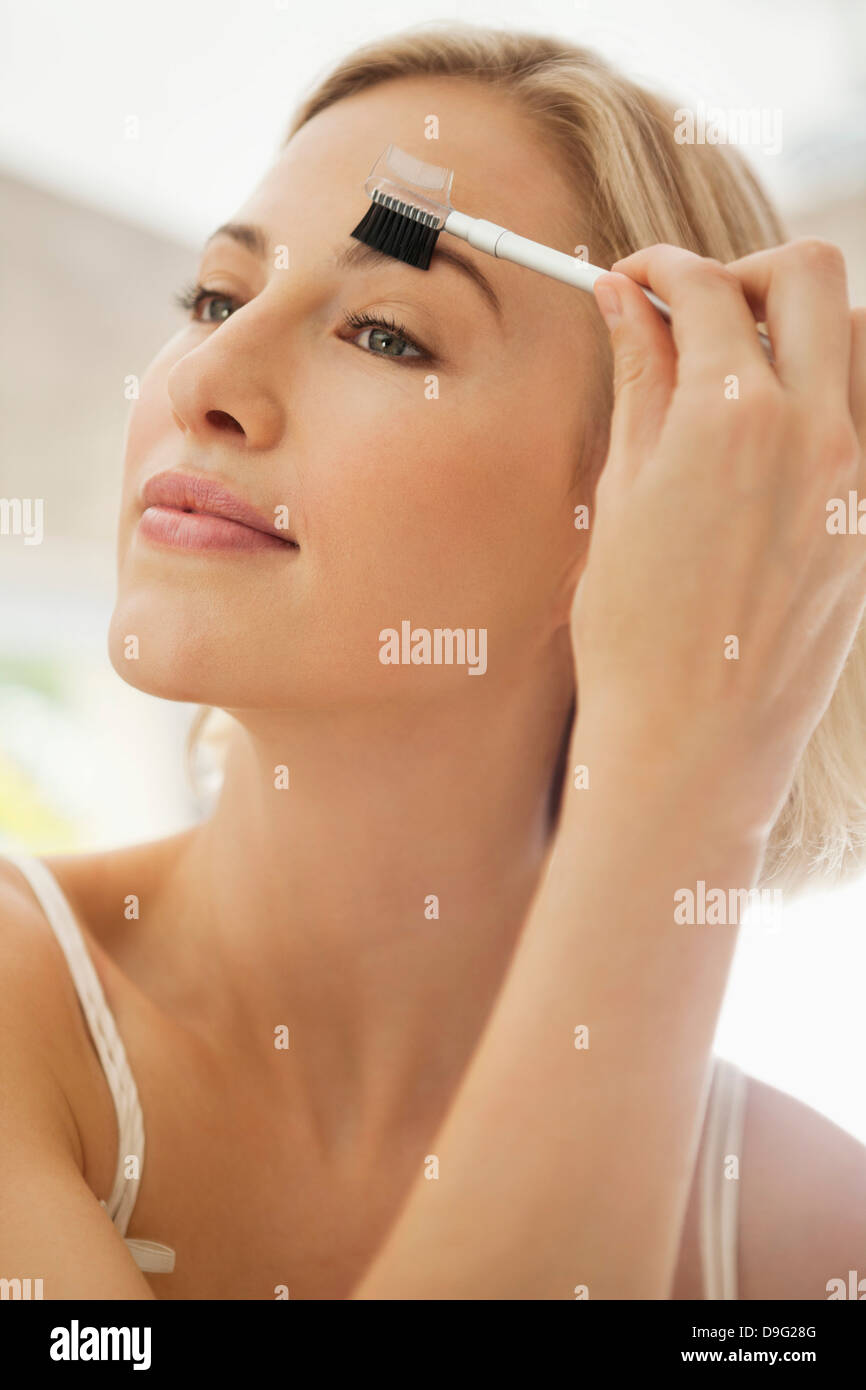 Woman brushing her eyebrows Stock Photo - Alamy
