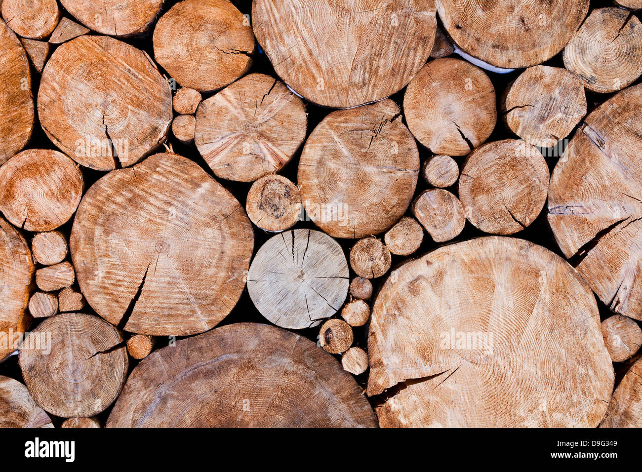 Stacked logs, wooden background Stock Photo - Alamy