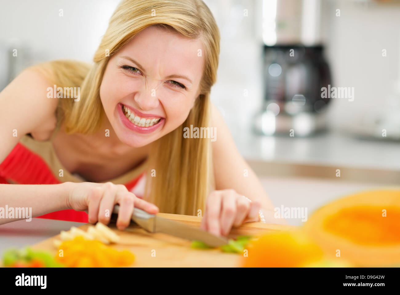Happy young woman cutting fruits in kitchen Stock Photo - Alamy
