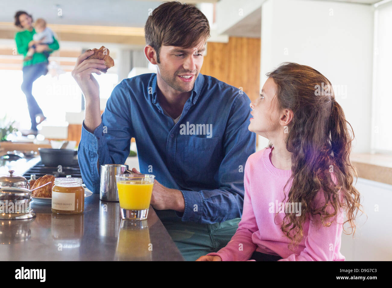 Man having breakfast with her daughter at a kitchen counter Stock Photo ...