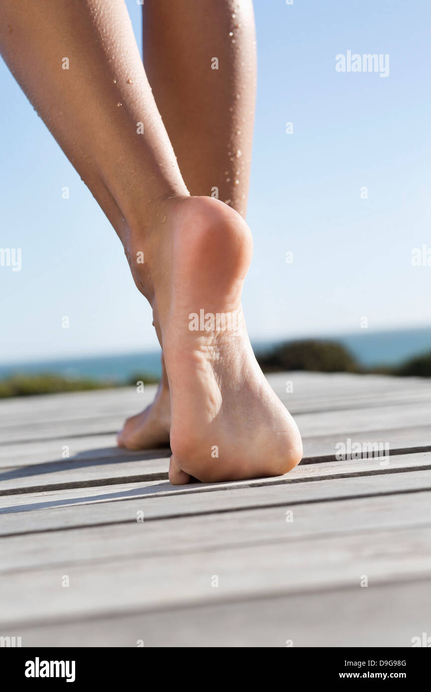 Low section view of a woman walking on boardwalk on the beach Stock ...