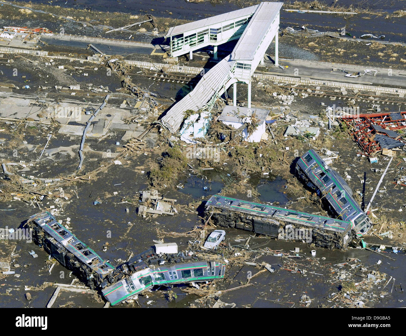 Train cars of the JR Joban Line are seen overturned on the ground ...