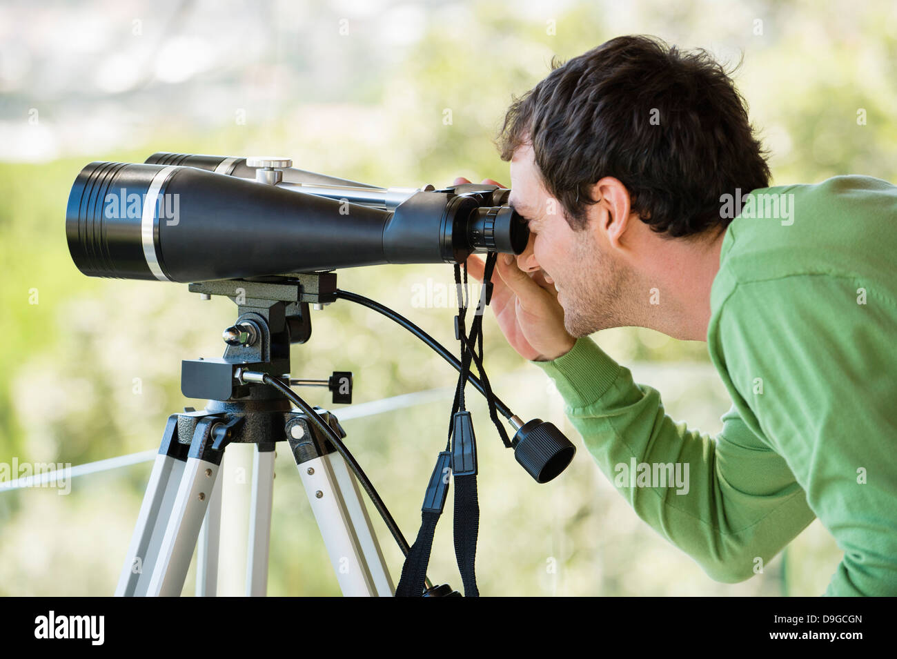 Man looking through binoculars Stock Photo - Alamy