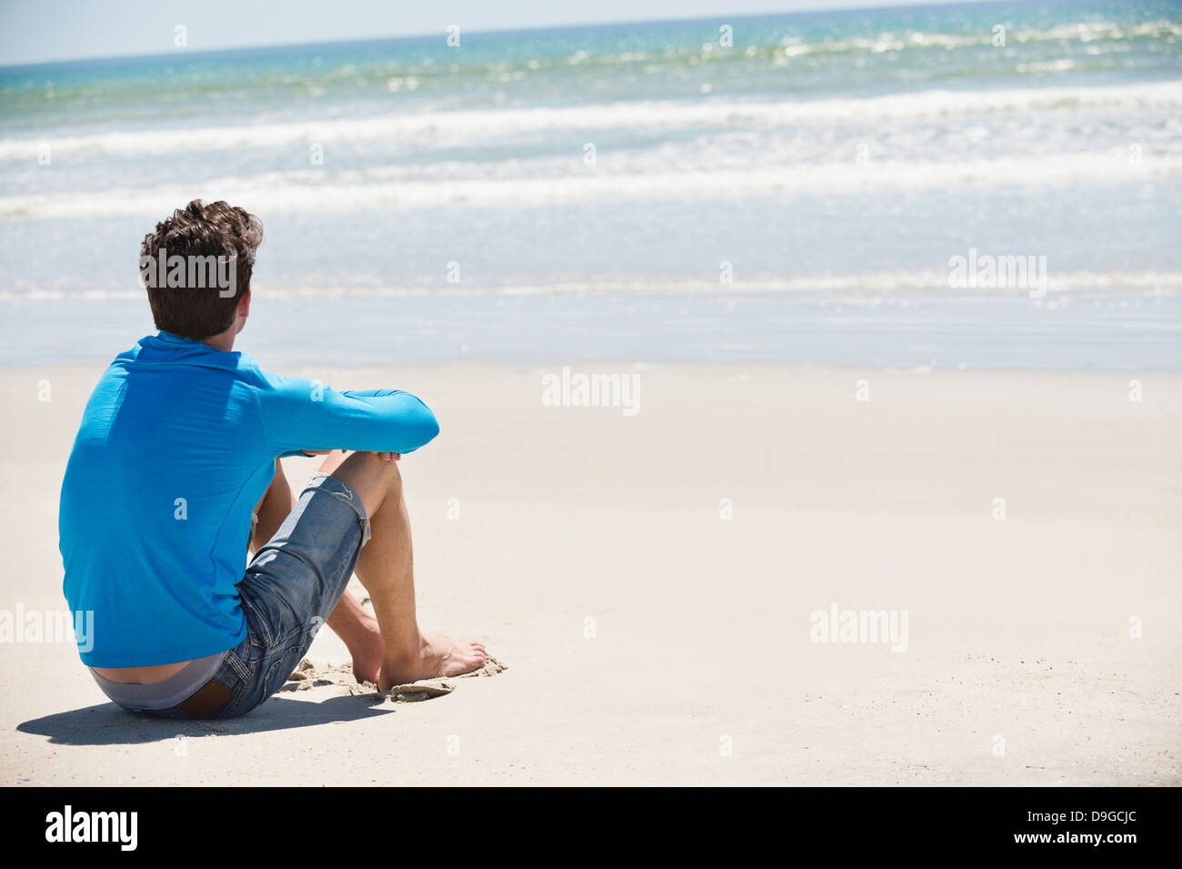 Man sitting on the beach Stock Photo - Alamy