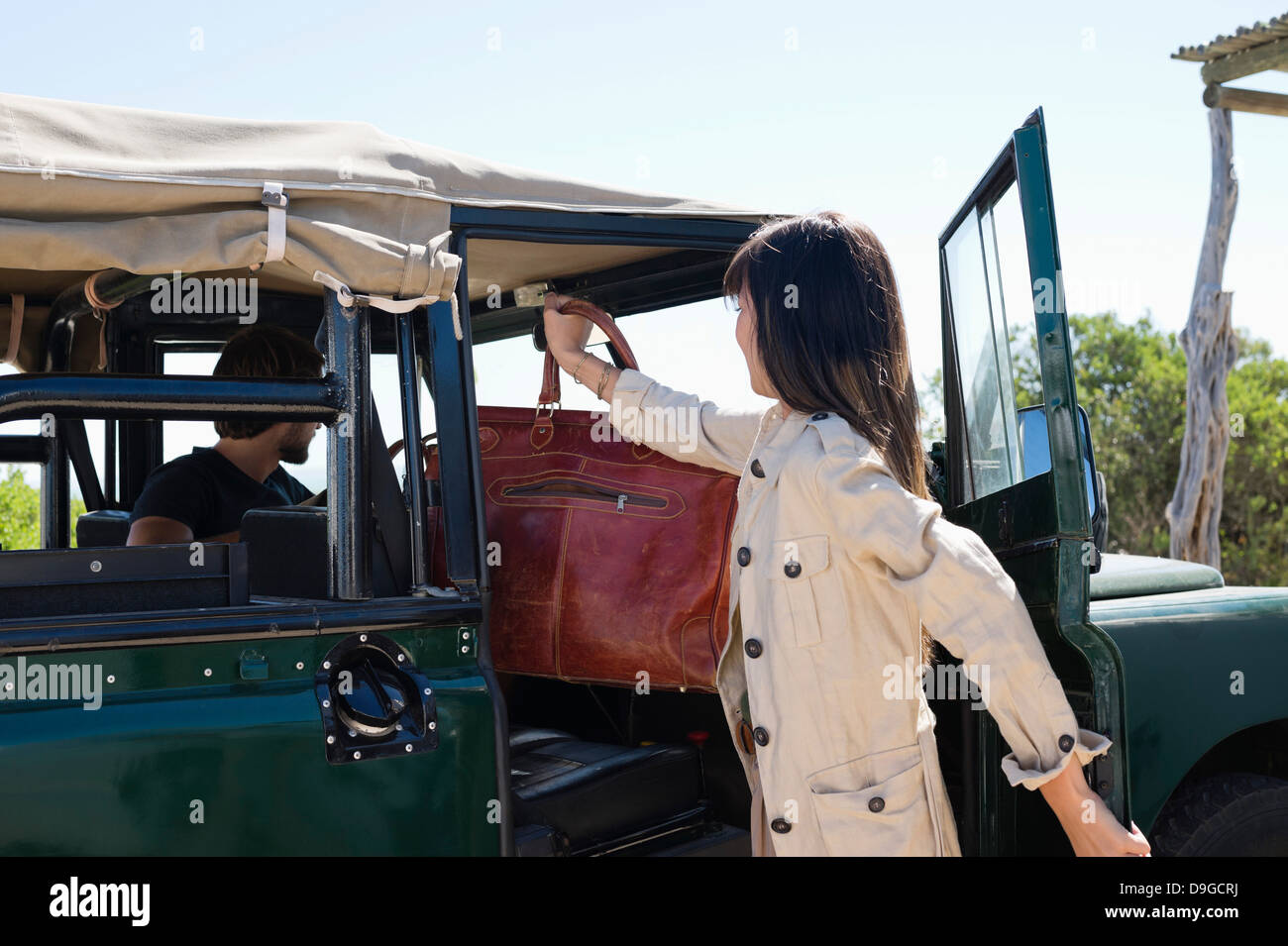 Woman putting handbag in SUV Stock Photo - Alamy