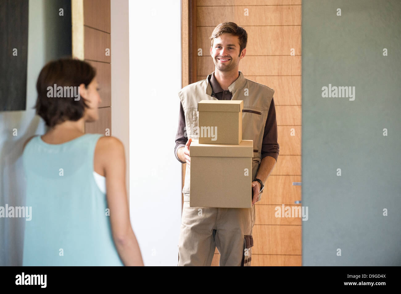 Delivery man delivering parcel to a woman Stock Photo - Alamy