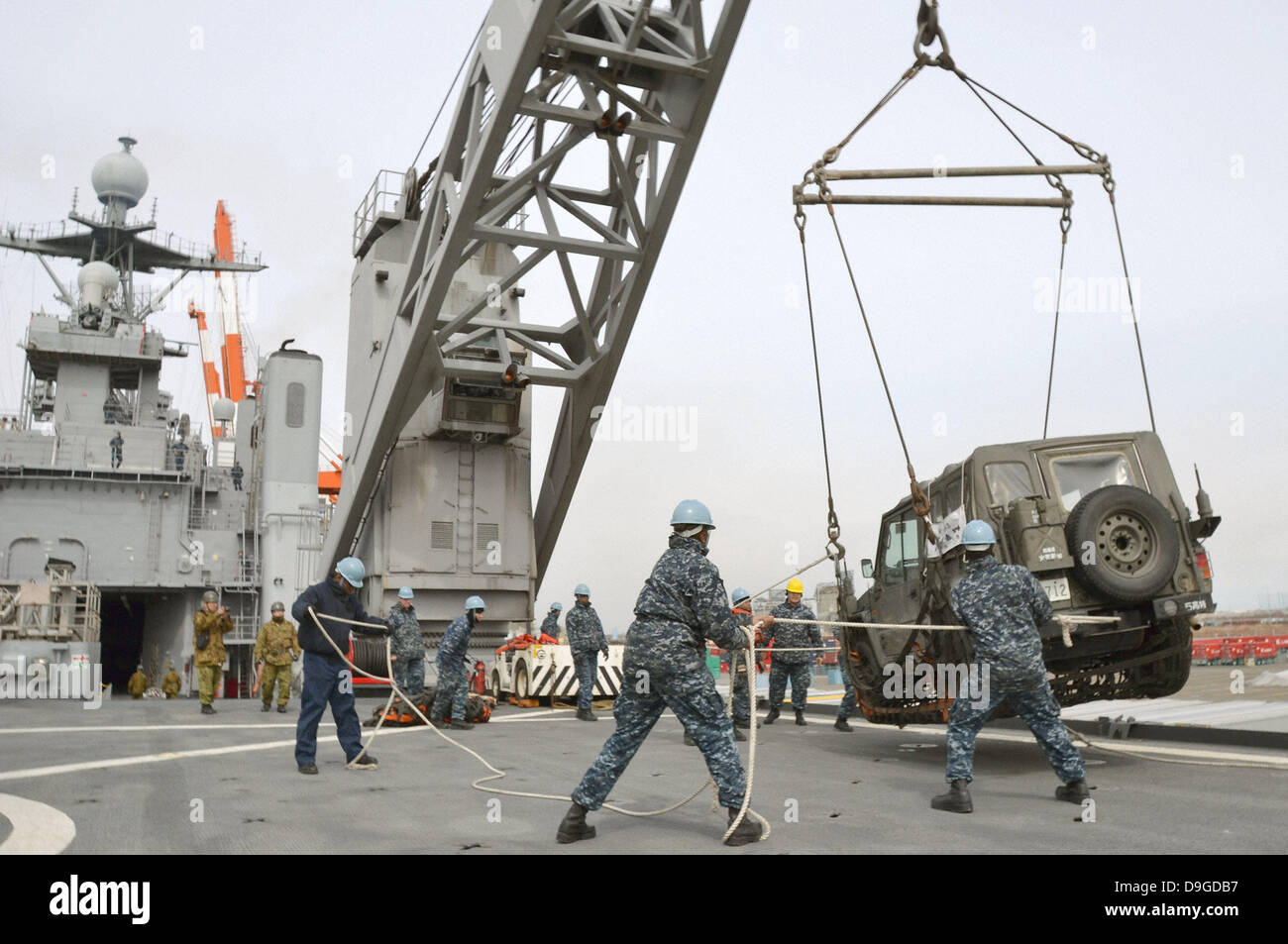 Members of the U.S. Navy load a Japan Ground Self-Defense Force vehicle ...