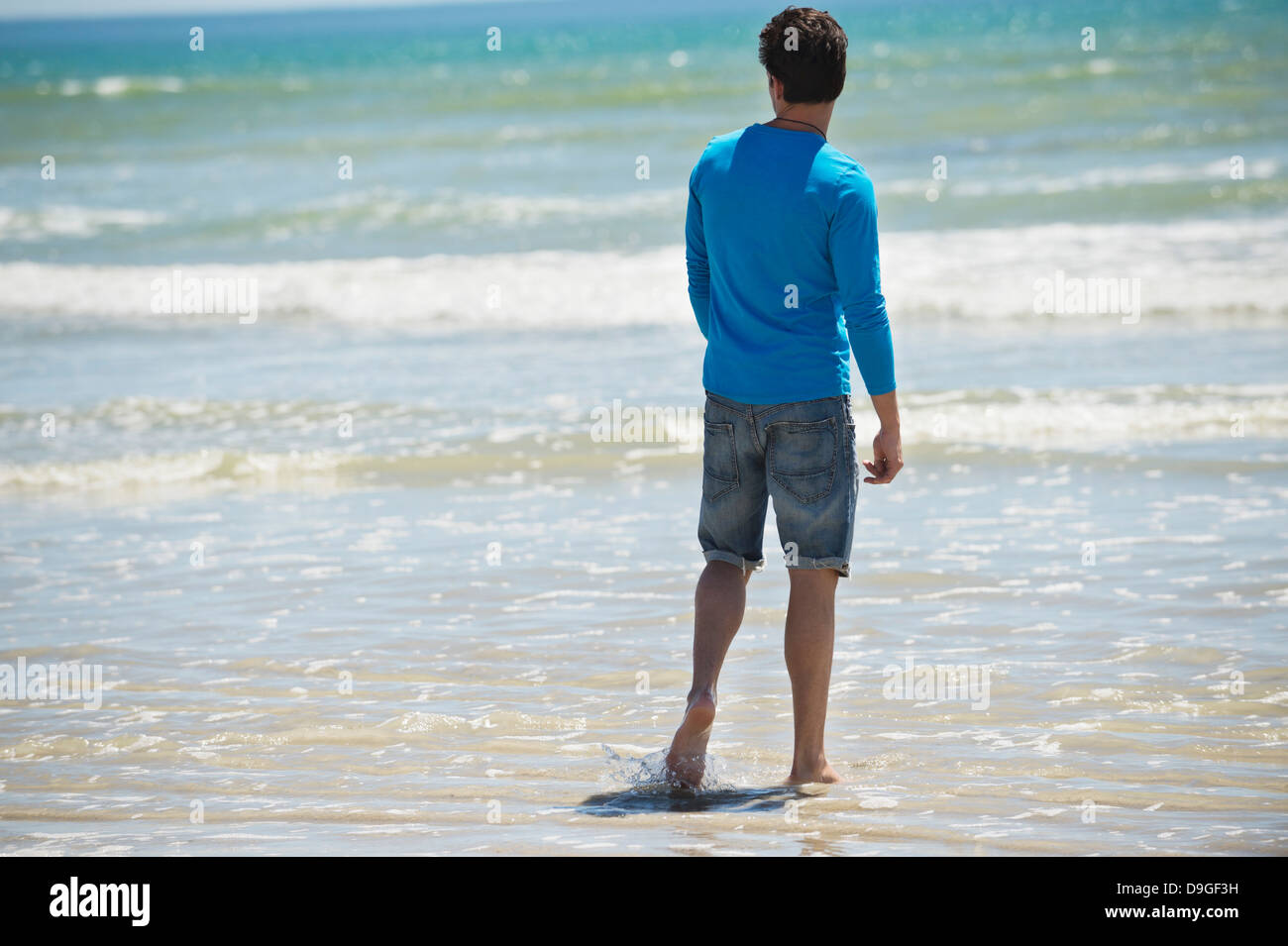 Man standing on the beach and looking at the sea Stock Photo - Alamy
