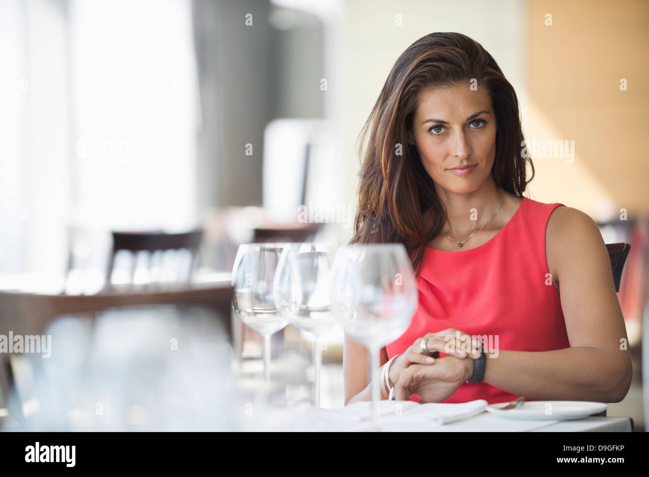 Woman sitting in a restaurant and looking at wristwatch Stock Photo - Alamy