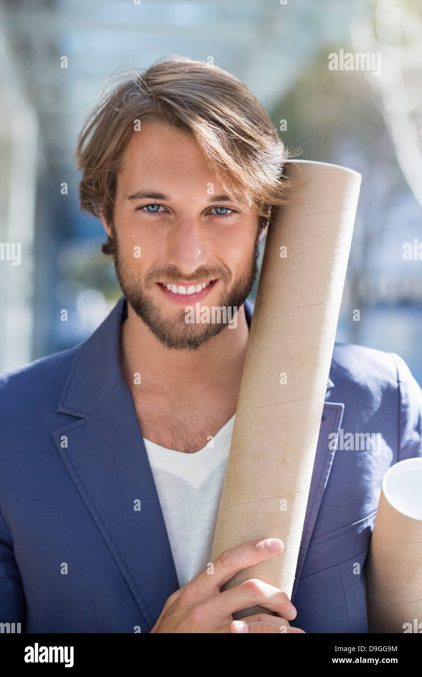 Portrait of an architect holding paper rolls and smiling Stock Photo ...