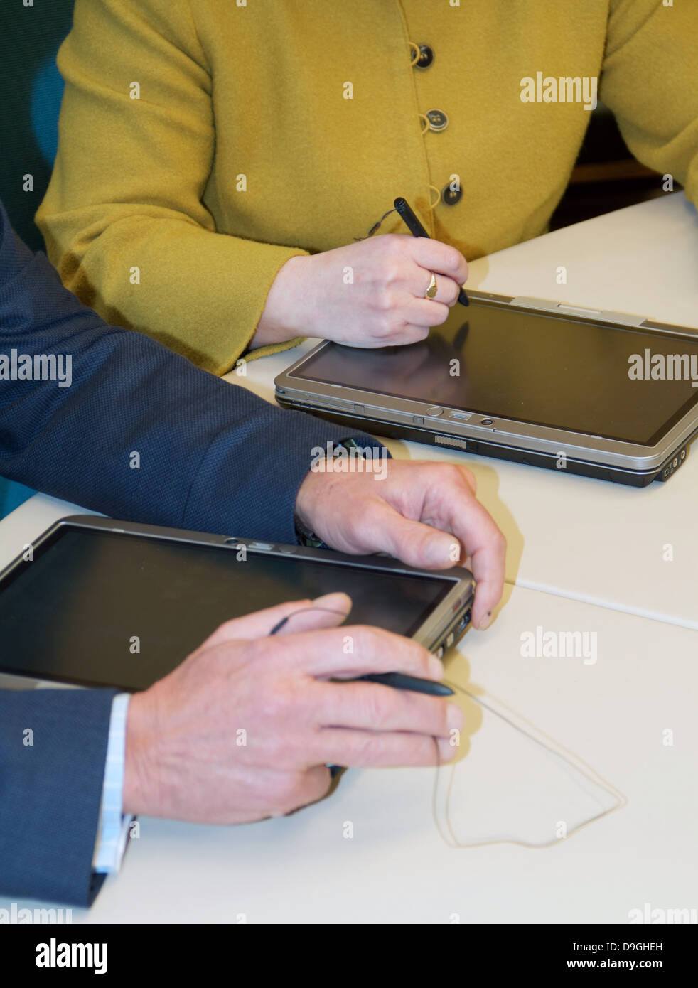 Two business people use their tablet computers in a meeting Stock Photo ...