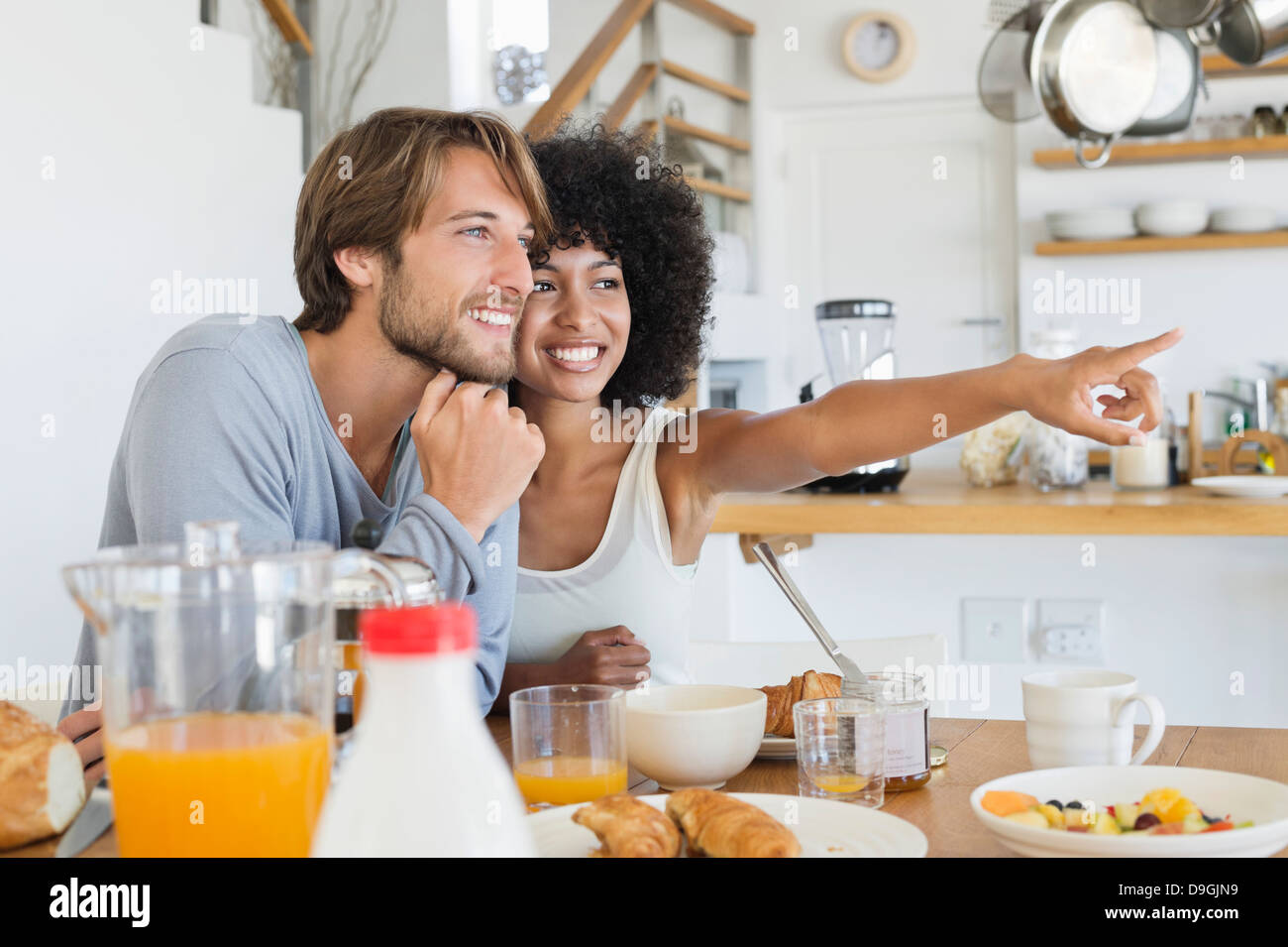 Smiling couple sitting at a dining table Stock Photo - Alamy