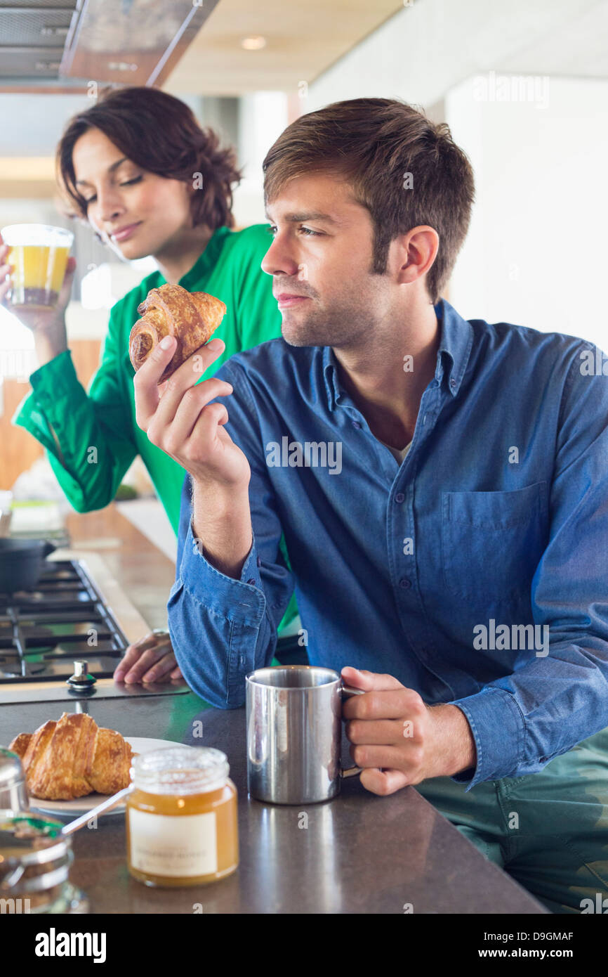 Couple having breakfast at a kitchen counter Stock Photo - Alamy