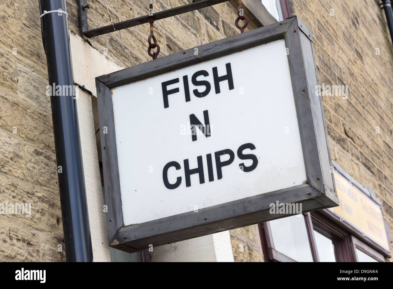 Sign on exterior stone wall outside a fish and chip shop on Charlestown ...