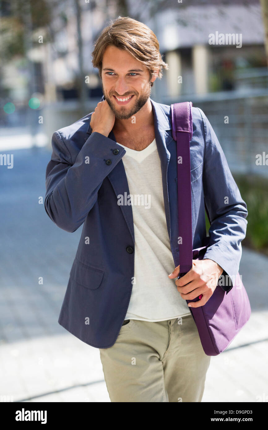 Man walking on a street and smiling Stock Photo - Alamy