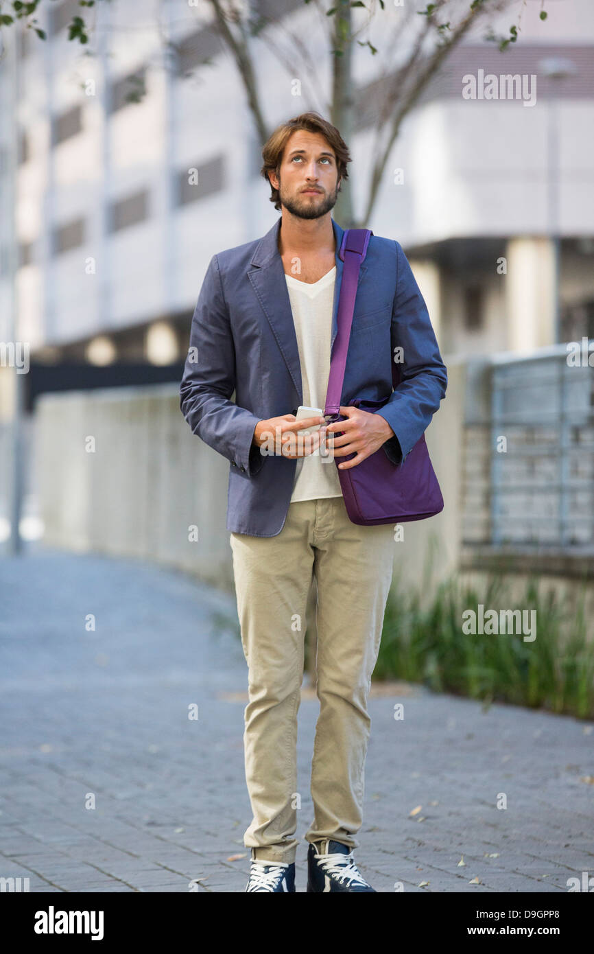 Man standing on a street looking up Stock Photo - Alamy