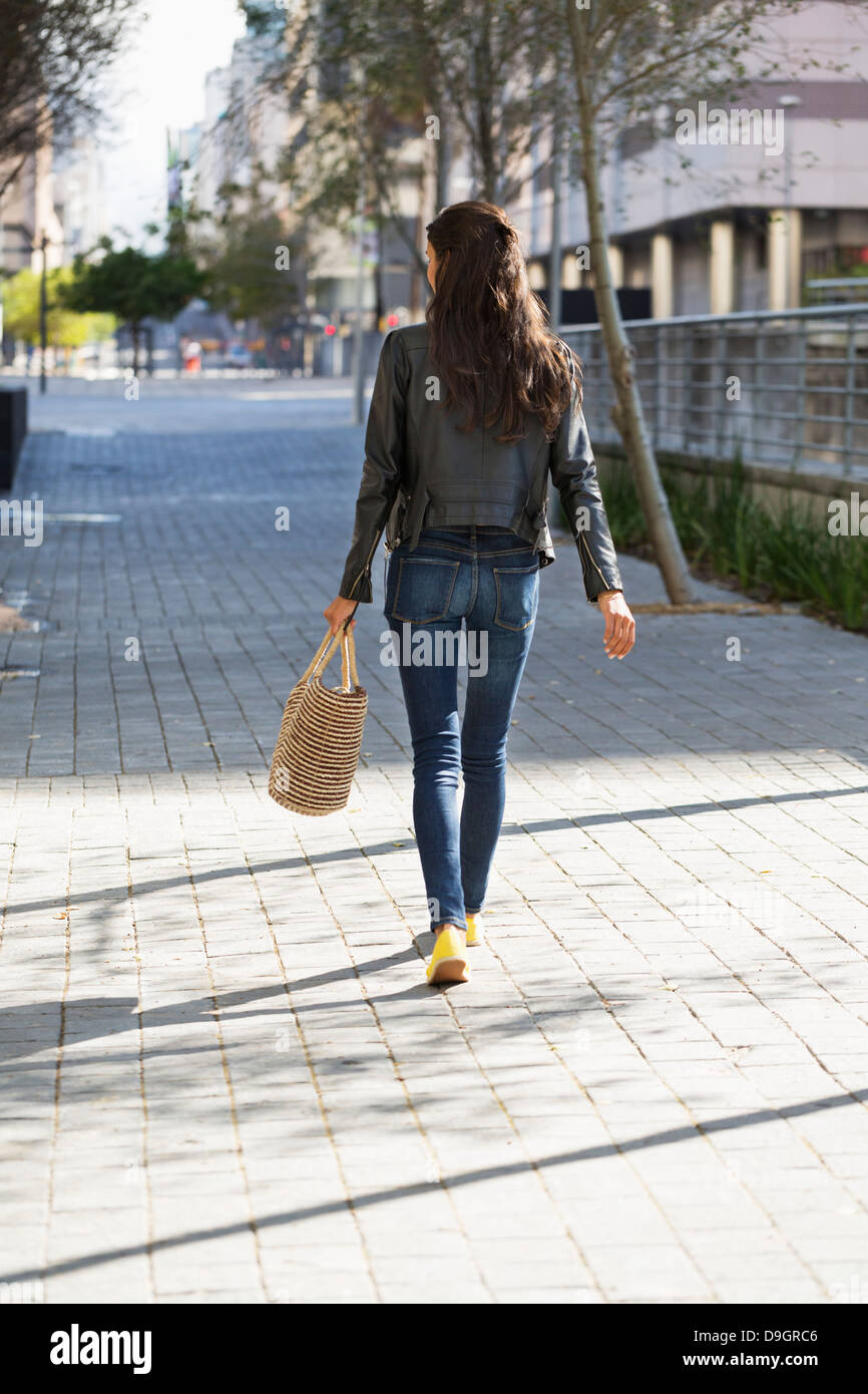 Rear view of a woman walking with a handbag Stock Photo - Alamy