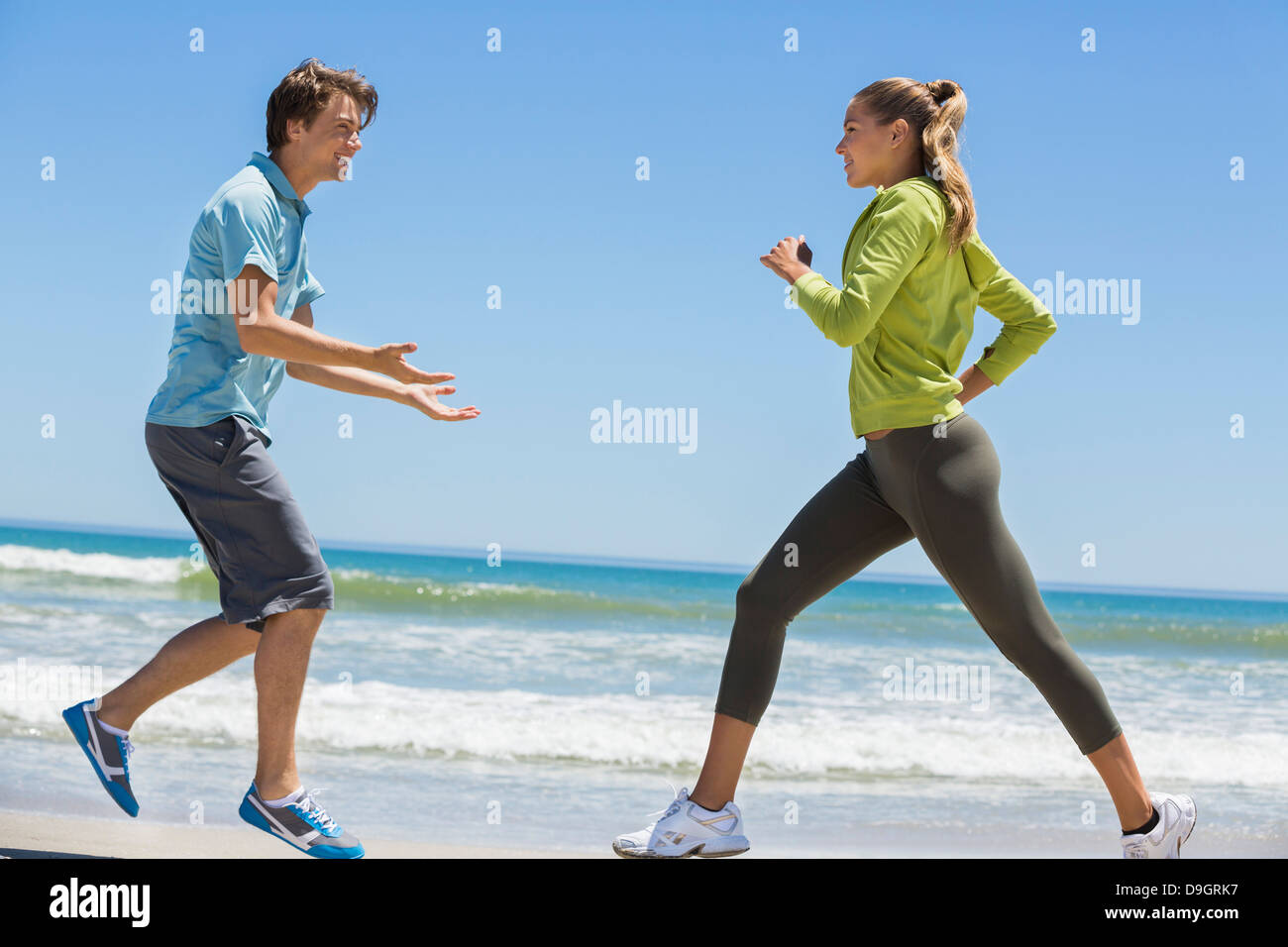 Woman jogging on the beach with her coach Stock Photo - Alamy