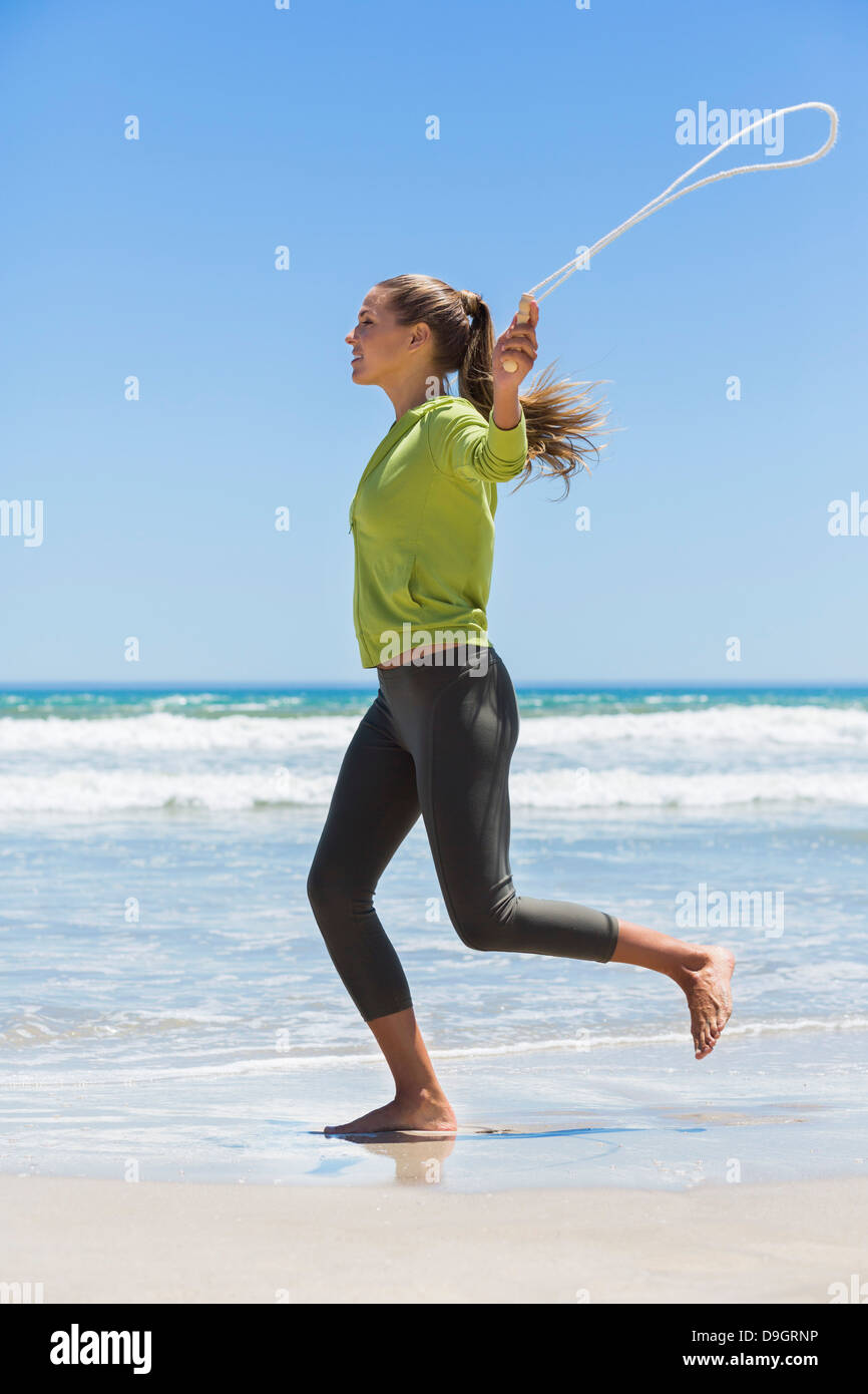 Woman jumping rope on the beach Stock Photo - Alamy