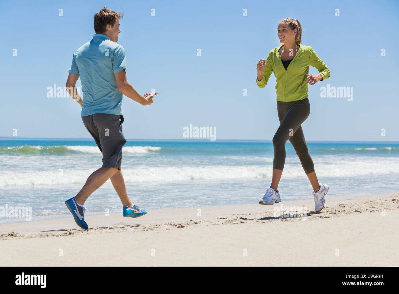 Woman jogging on the beach with her coach Stock Photo - Alamy