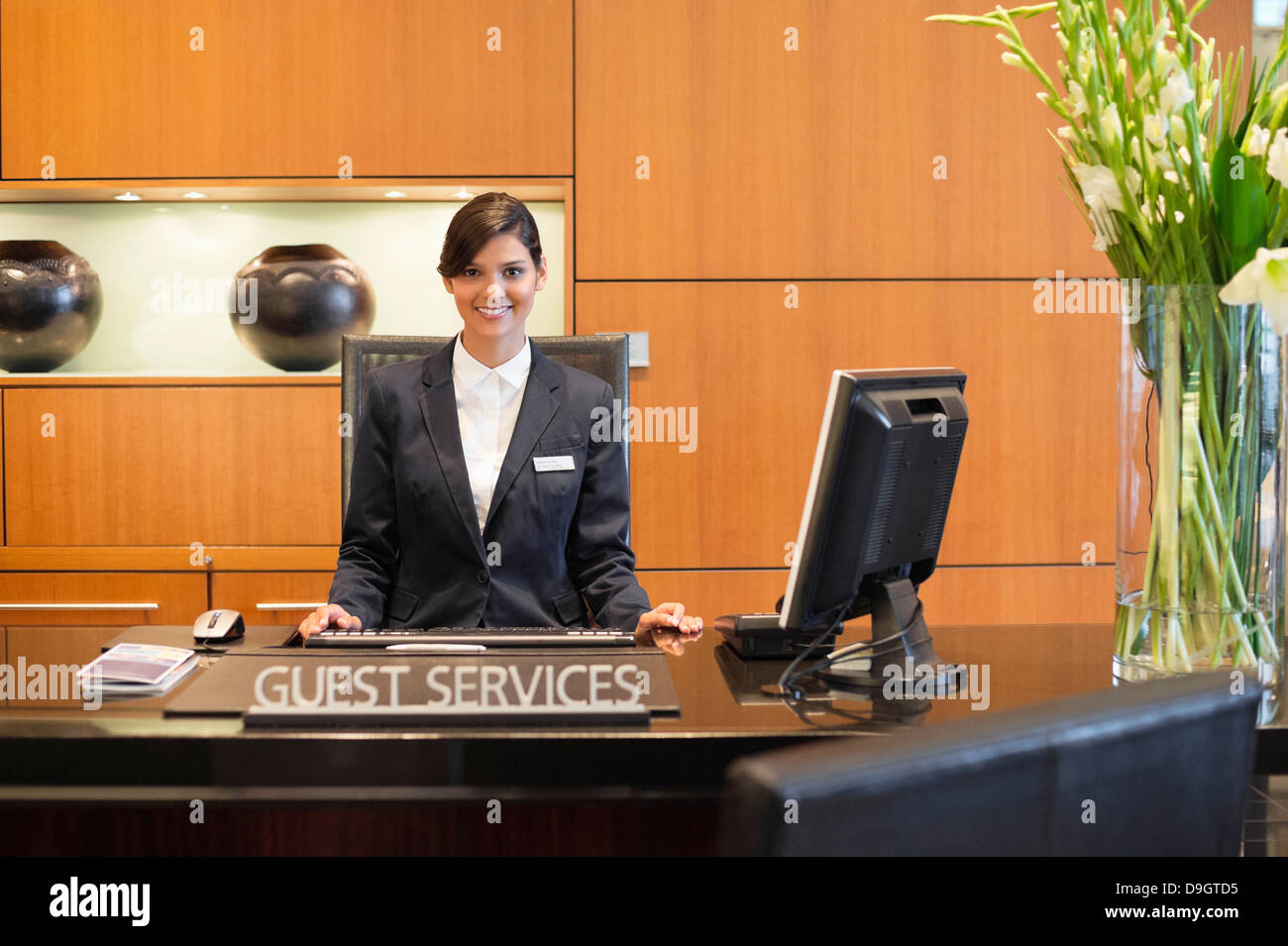 Portrait of a receptionist smiling at the hotel reception counter Stock ...