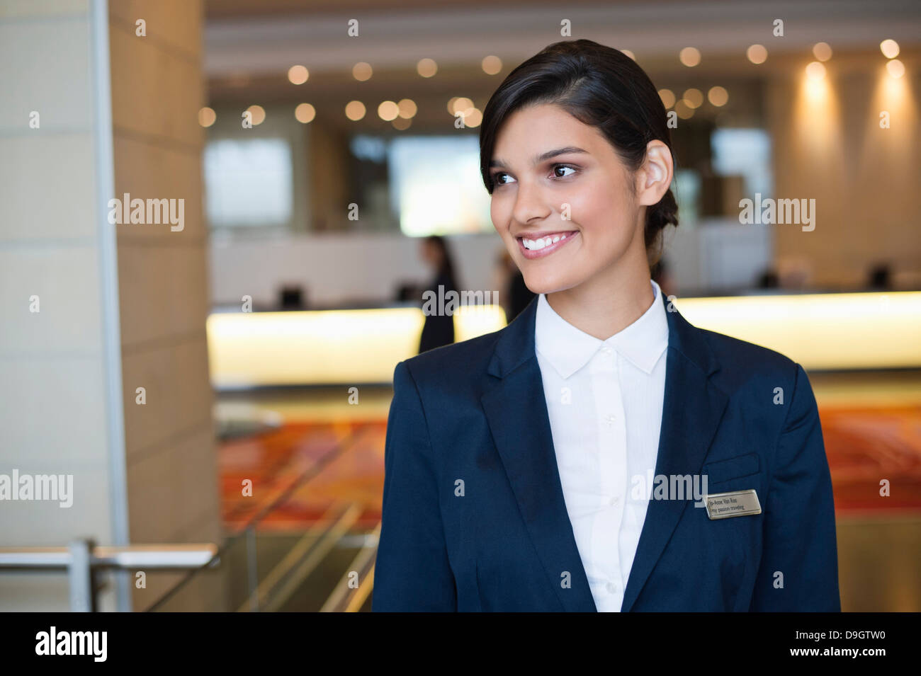 Receptionist smiling in a hotel lobby Stock Photo - Alamy