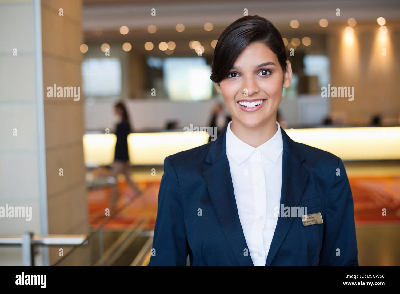 Portrait of a receptionist smiling in a hotel lobby Stock Photo - Alamy