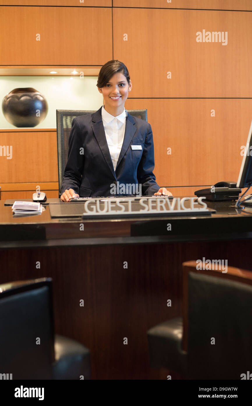 Portrait of a receptionist smiling at the hotel reception counter Stock ...