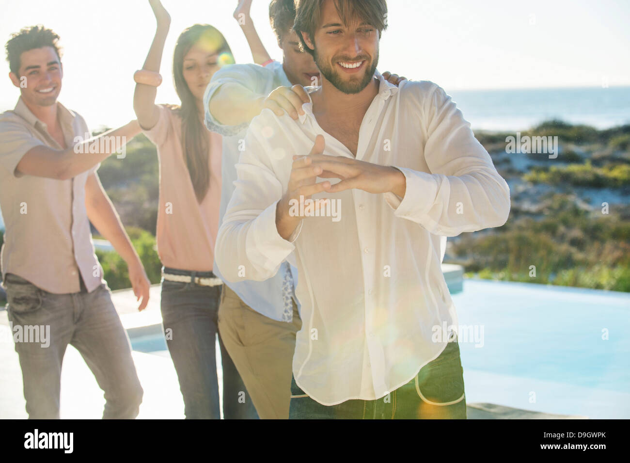 Group of friends dancing at the poolside Stock Photo - Alamy