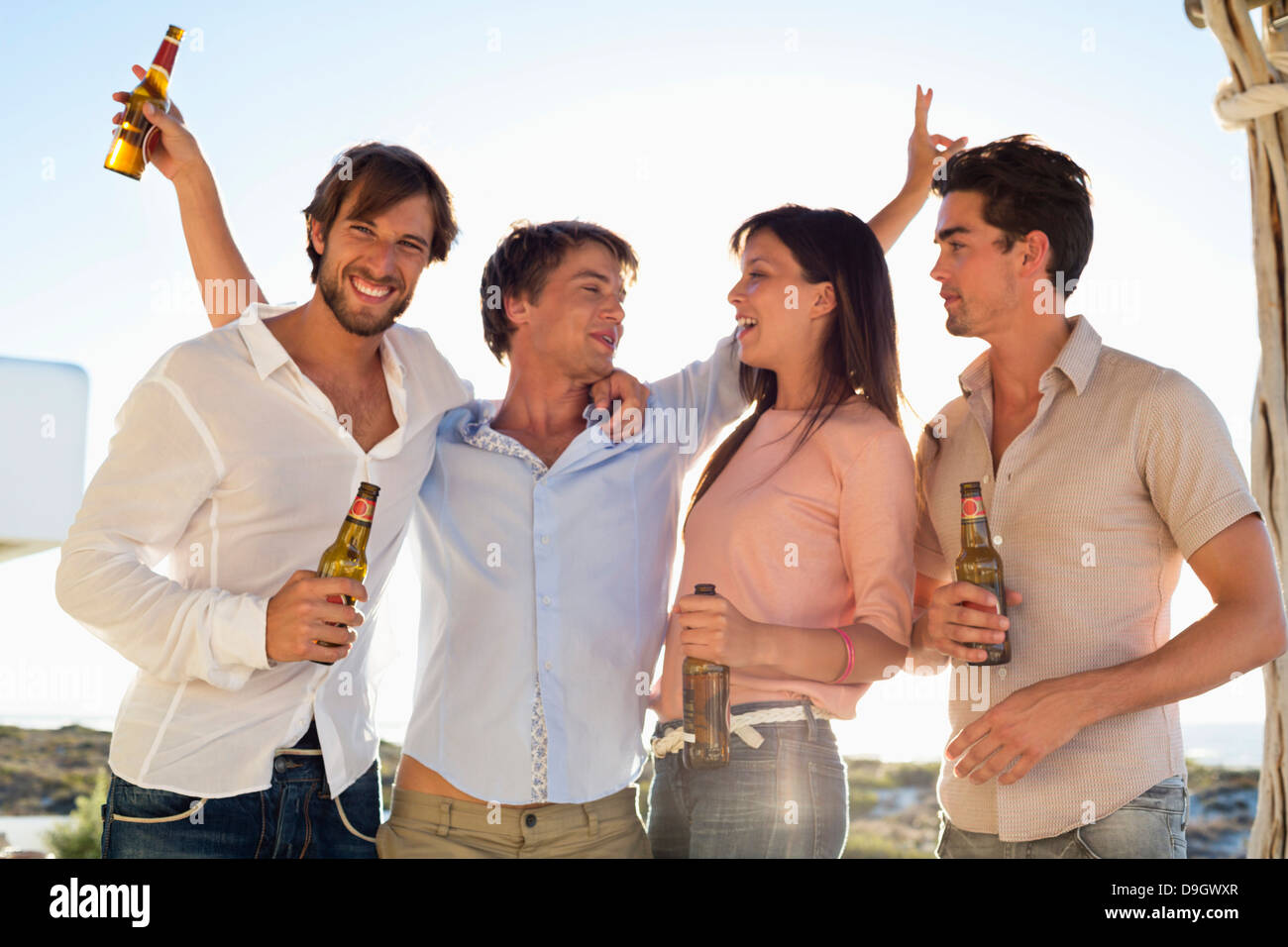 Four friends drinking beer Stock Photo - Alamy