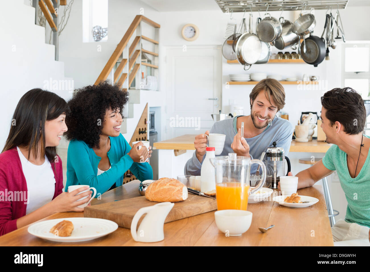 Friends sitting at a dining table having breakfast Stock Photo - Alamy
