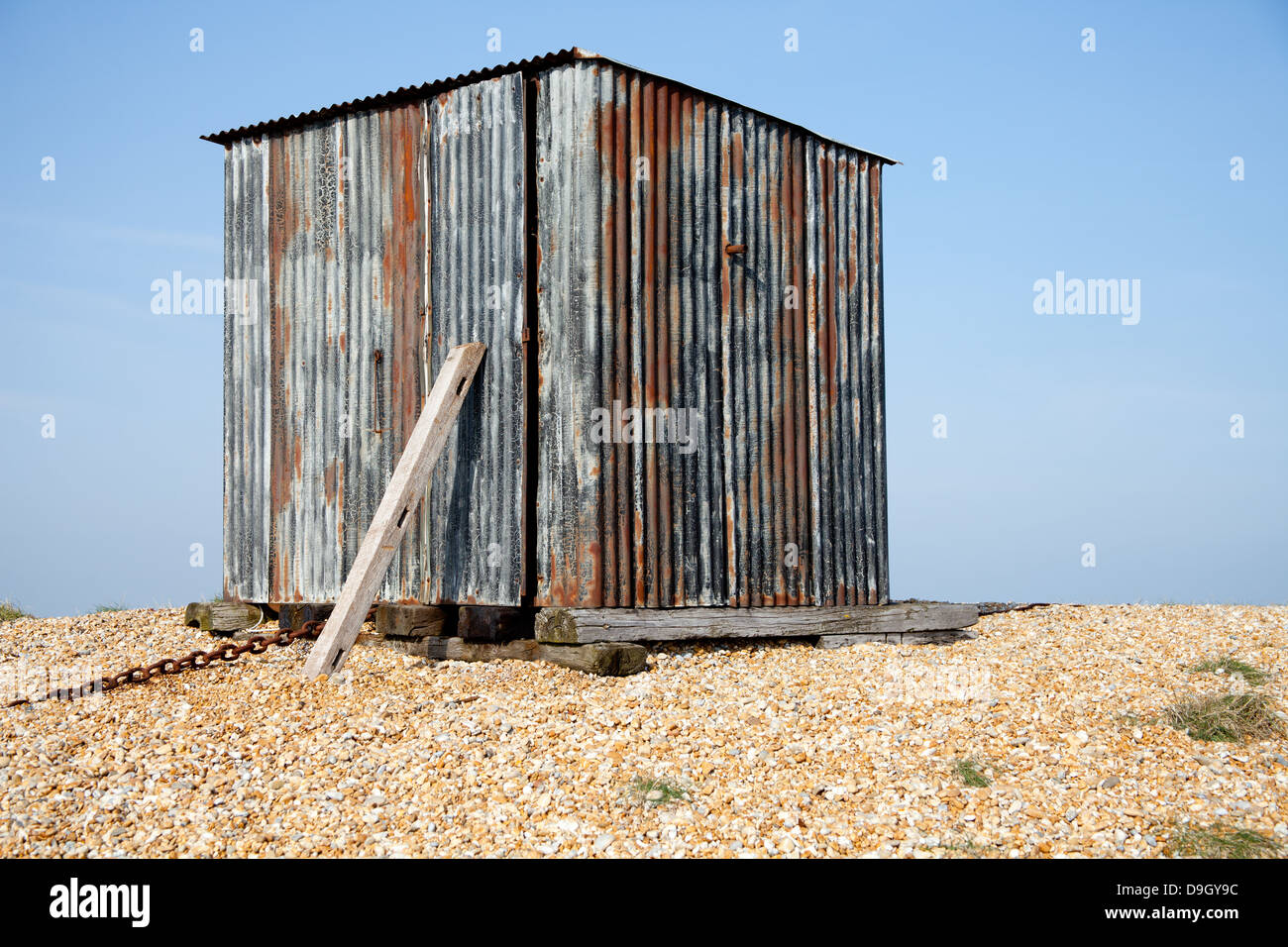 Metal shed/container on pebble beach against a clear blue sky Stock ...