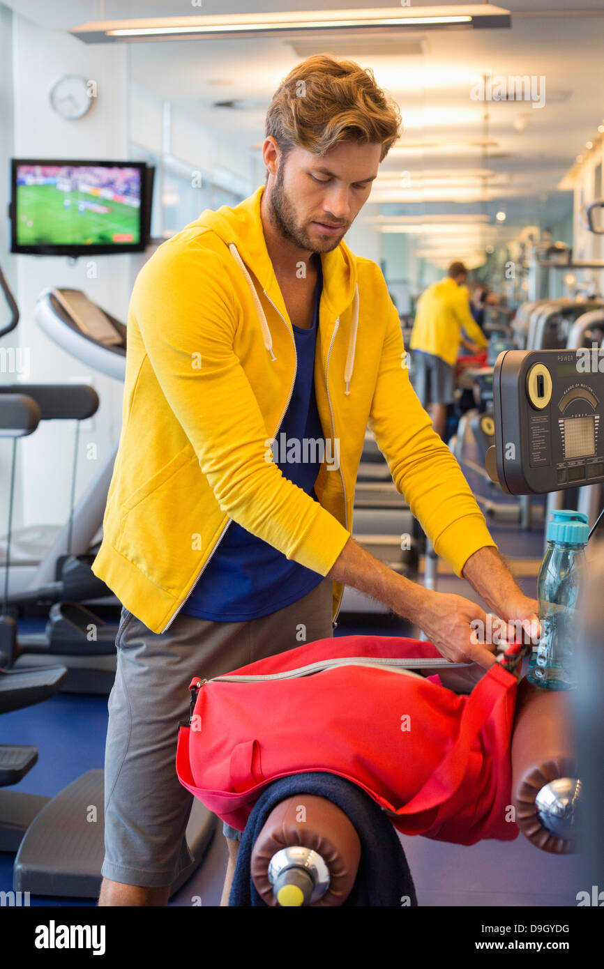 Man packing his bag in a gym after workout Stock Photo - Alamy